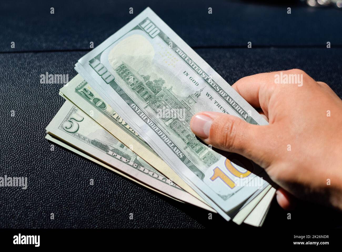 man hands over money in a car. A wad of dollars in his hand Stock Photo ...