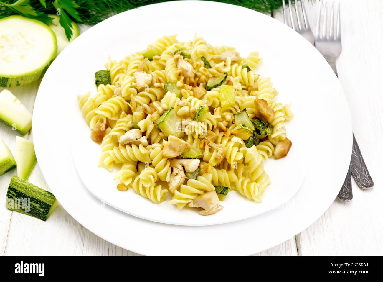 Fusilli with chicken and zucchini in two plates on white board Stock ...