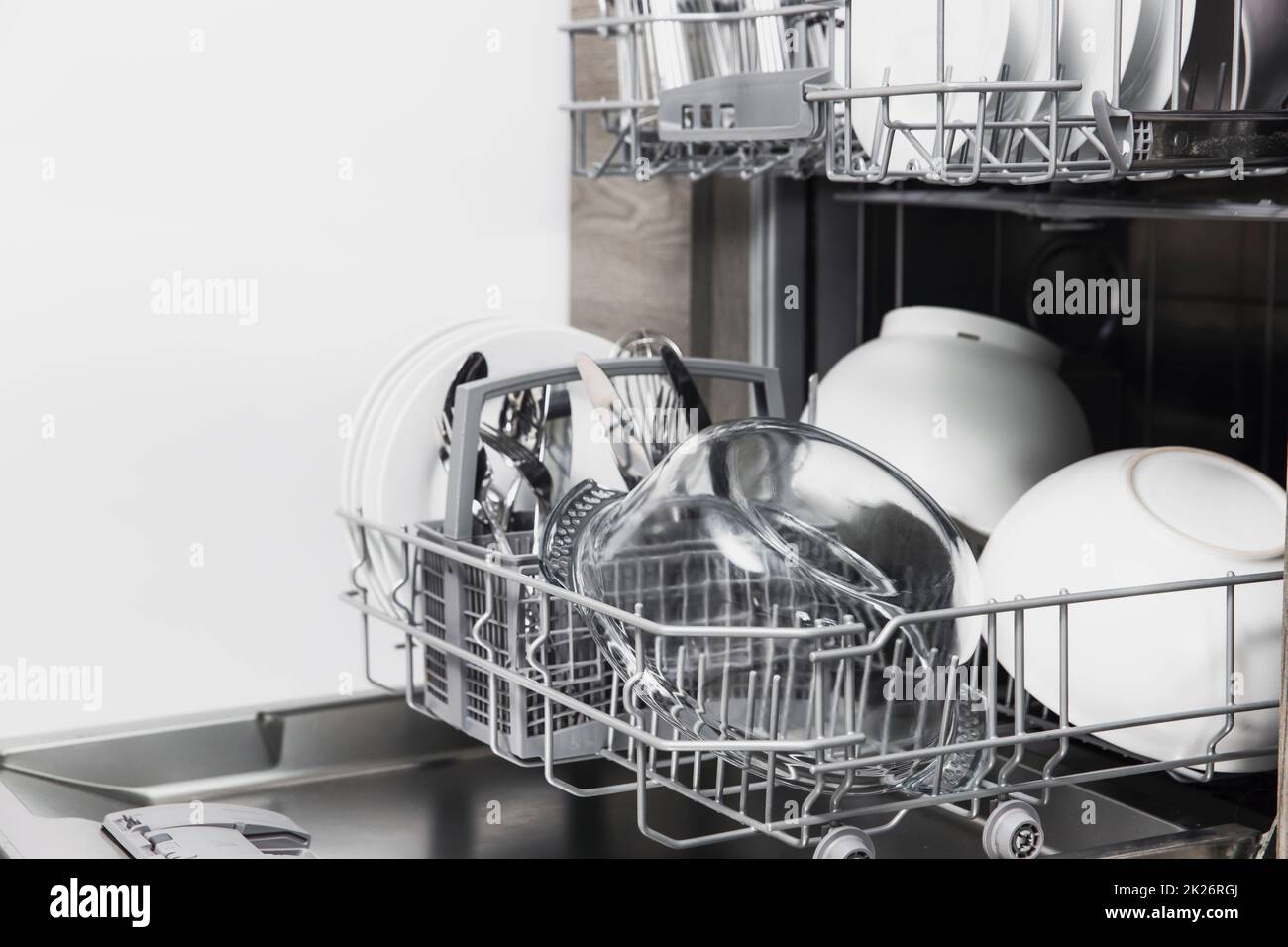 Open dishwasher with clean utensil inside, cutlery, glasses, dishes at ...