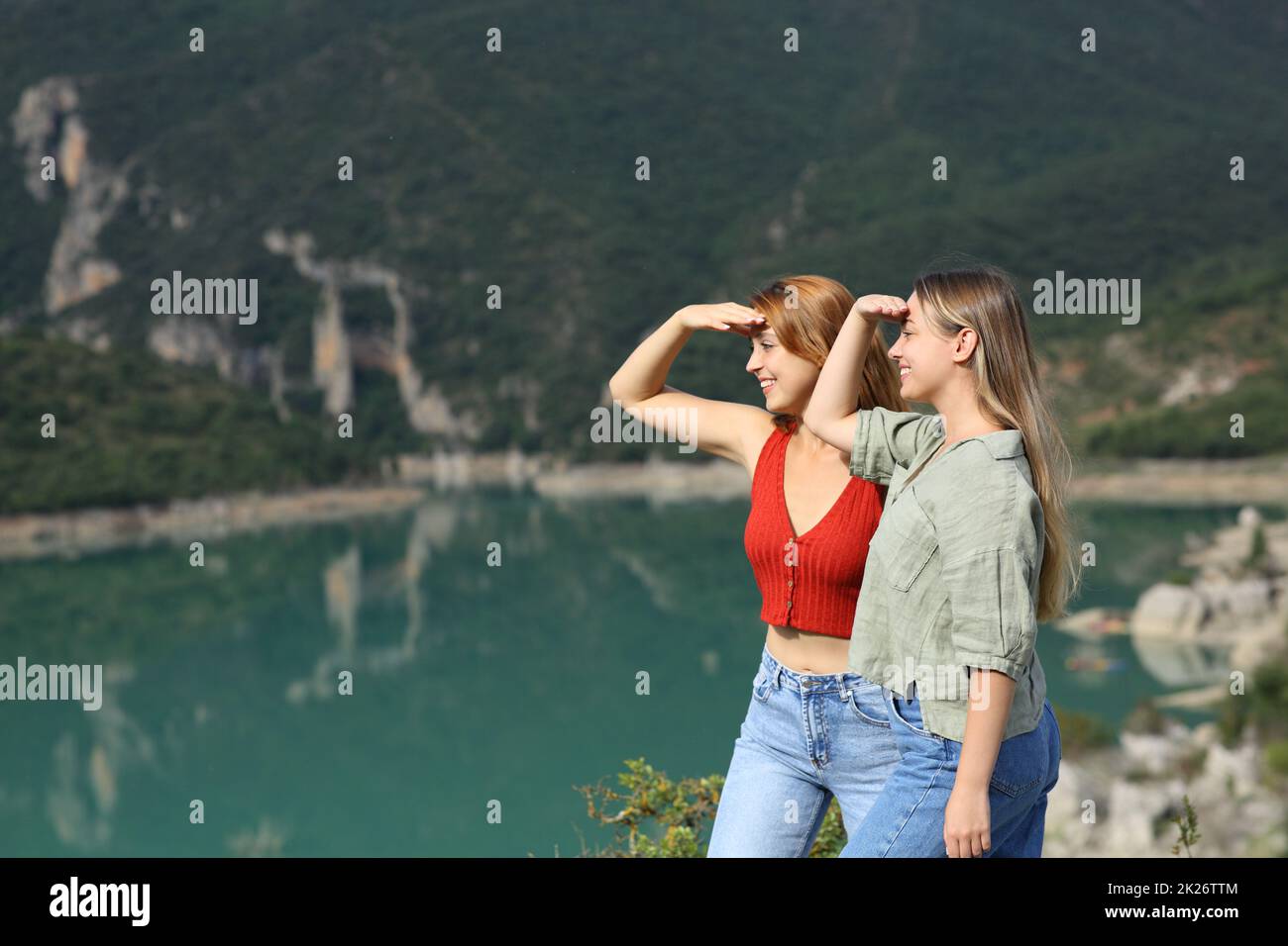 Two friends looking protecting from sun in the mountain Stock Photo - Alamy
