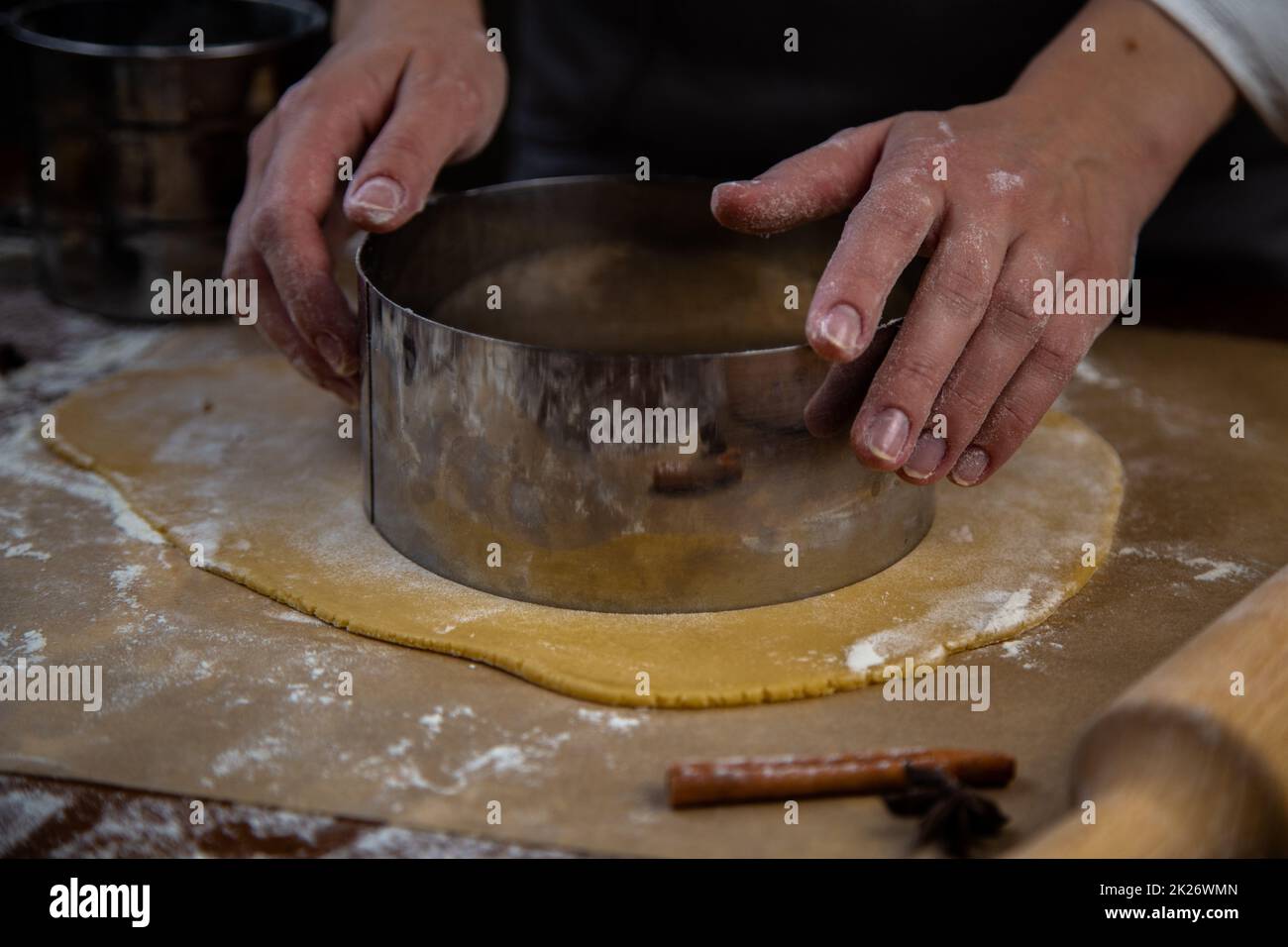 The rolled out layer of dough lies on baking paper, a cake cake is cut ...