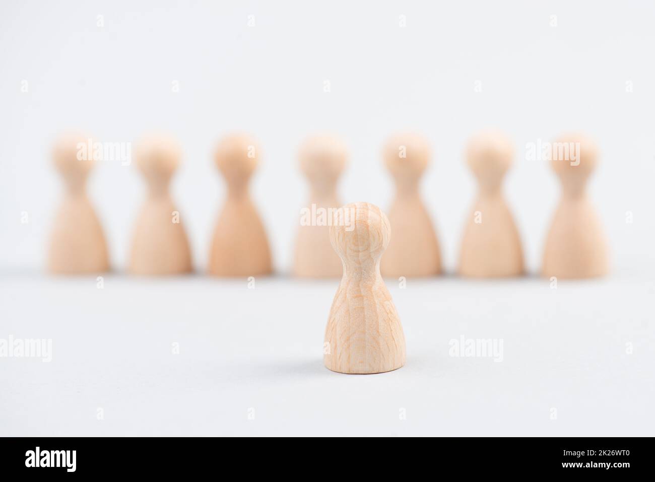 Group of people standing together, one leader standing in front of them ...