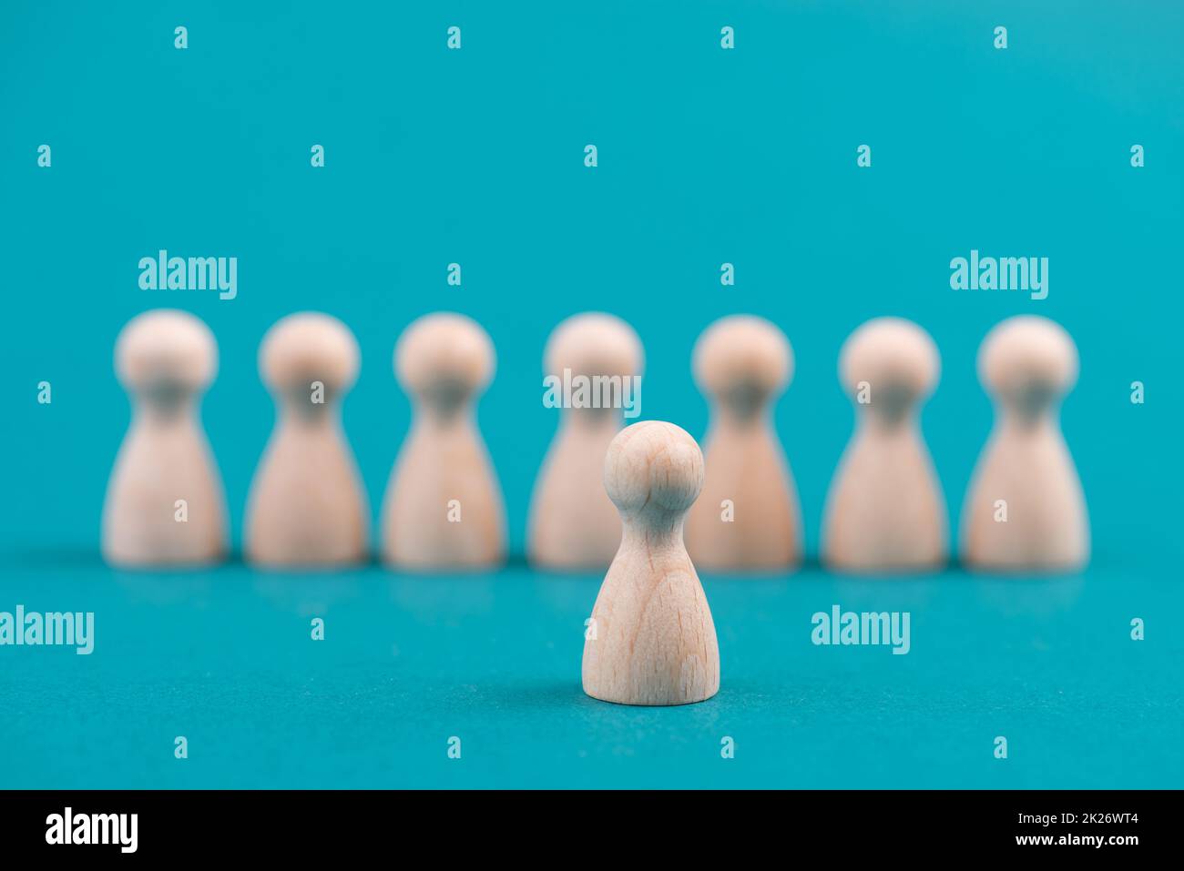 Group of people standing together, one leader standing in front of them ...