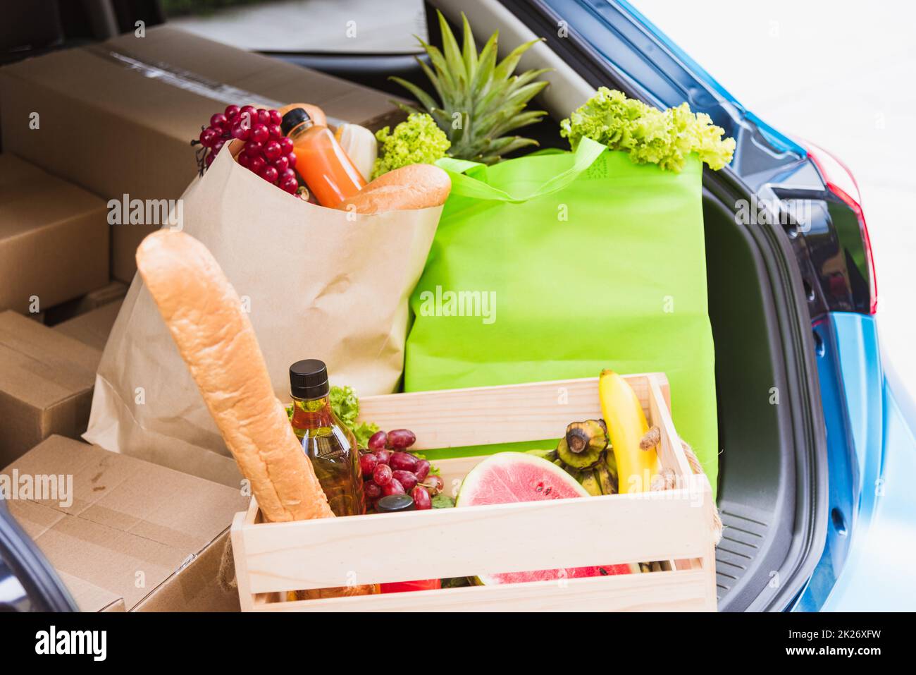 Grocery service giving fresh vegetables in wooden basket on back car ...
