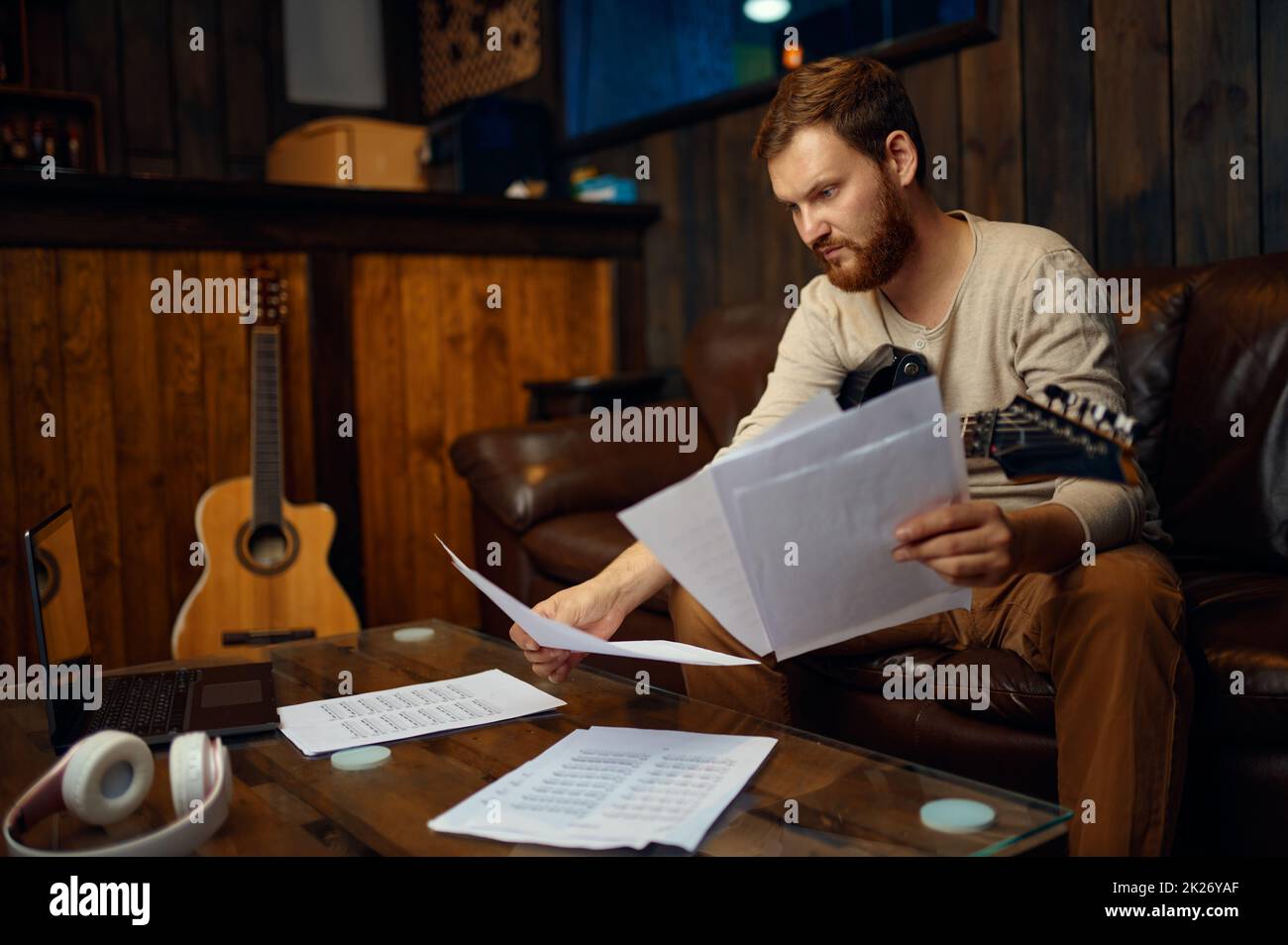Young guy guitarist learning reading music notes Stock Photo - Alamy