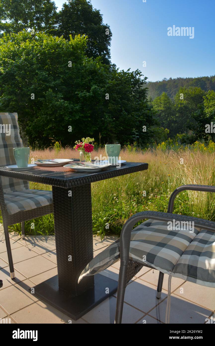 Breakfast on the terrace in front of green nature on a beautiful summer ...