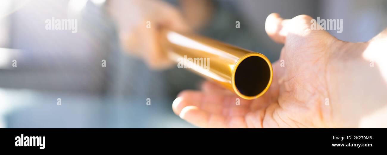 Hand Passing Golden Relay Baton Stock Photo - Alamy