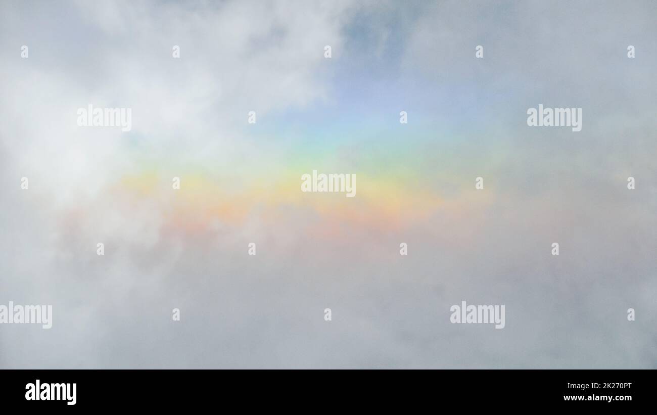 colorful rainbow was forming above white clouds after a rainstorm ...