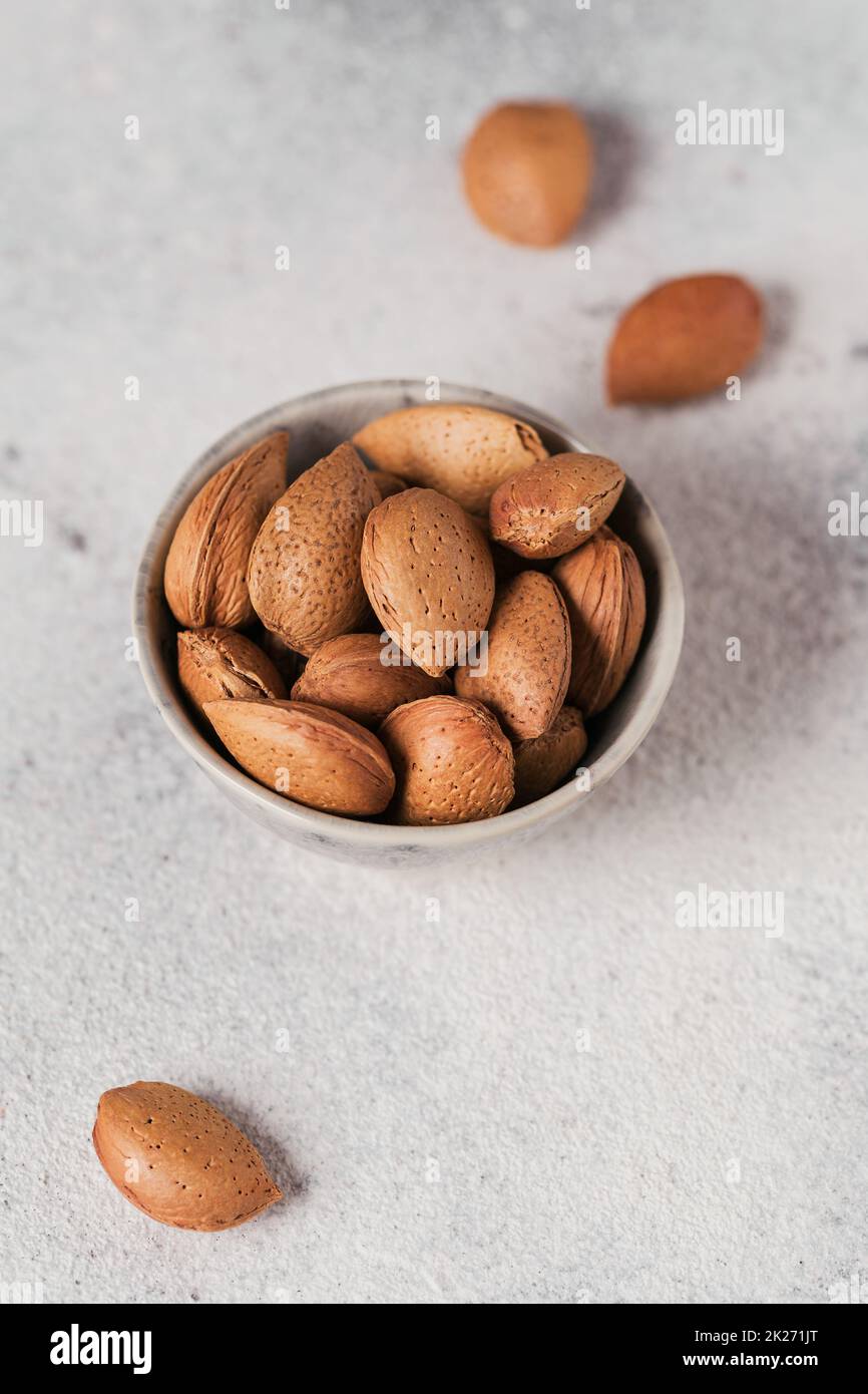 Pile of Almond nuts in a bowl on a white background Stock Photo - Alamy