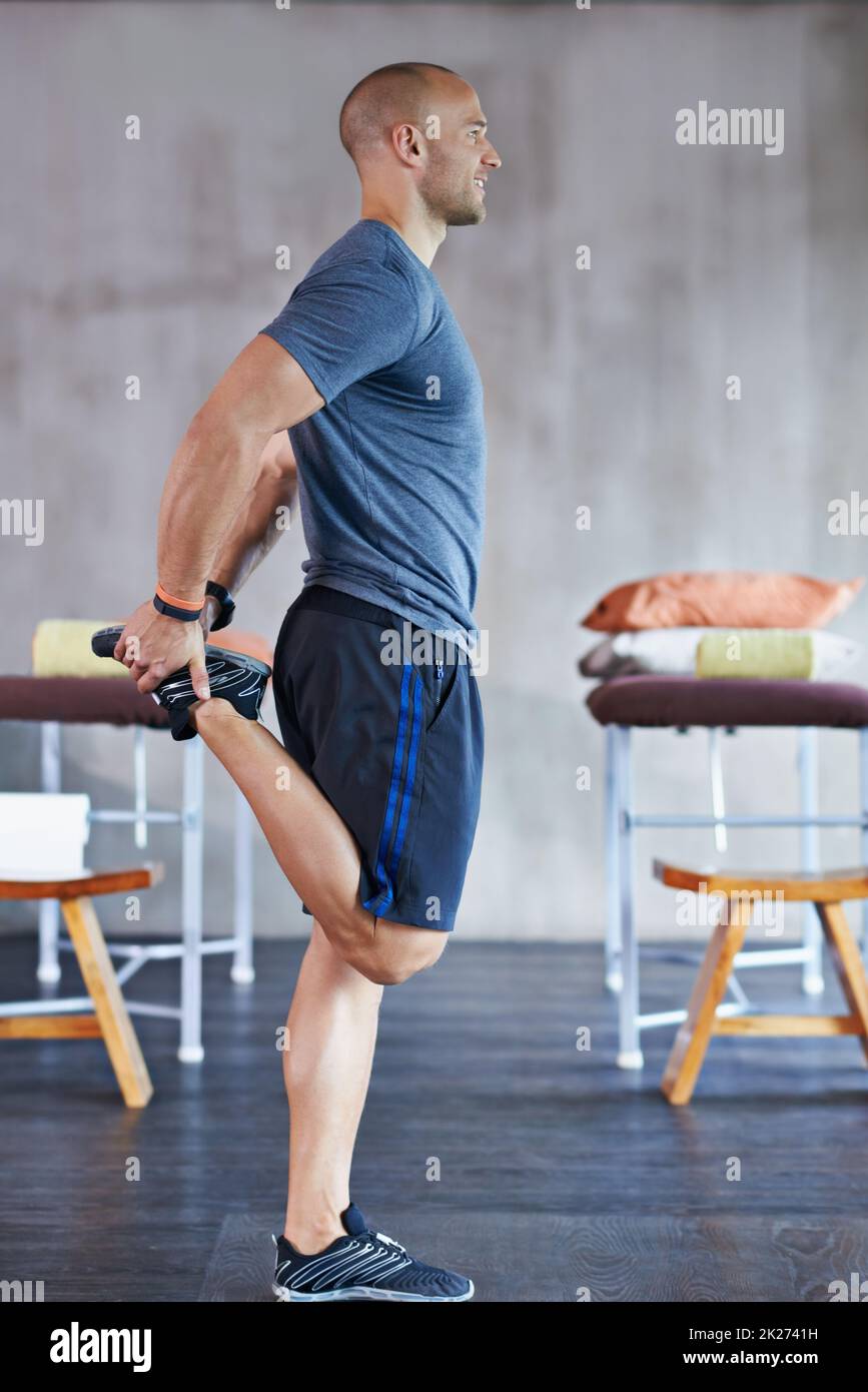 Limbering up. A cropped shot of a handsome trainer stretching before a ...