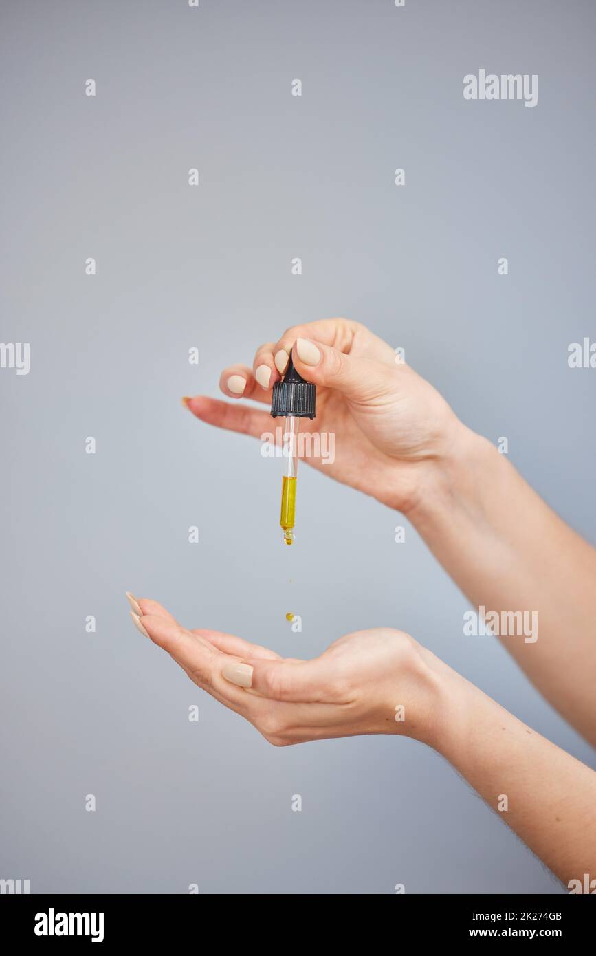 Just one drop does the trick. Shot of a young woman taking serum from a ...