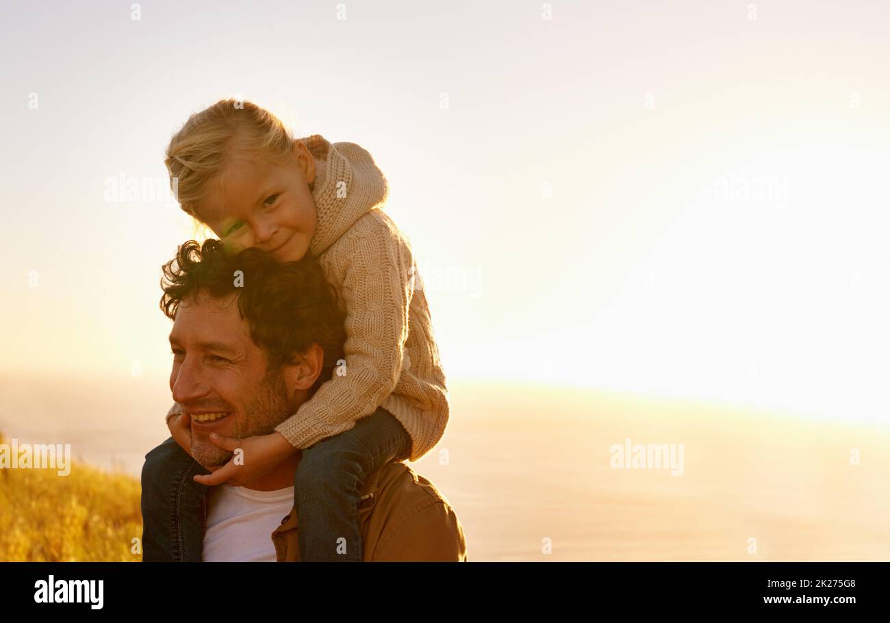 Her daddy and her hero. Cropped shot of a father giving his little girl a ride on his shoulders ...