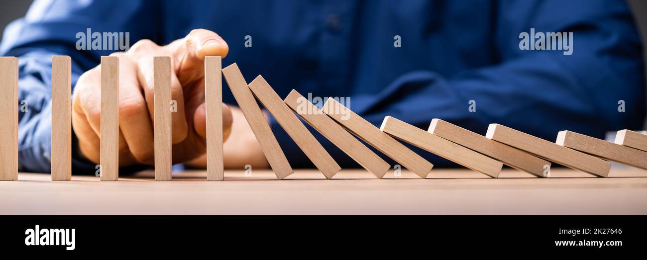 Stopping Falling Domino Continuity Stock Photo - Alamy