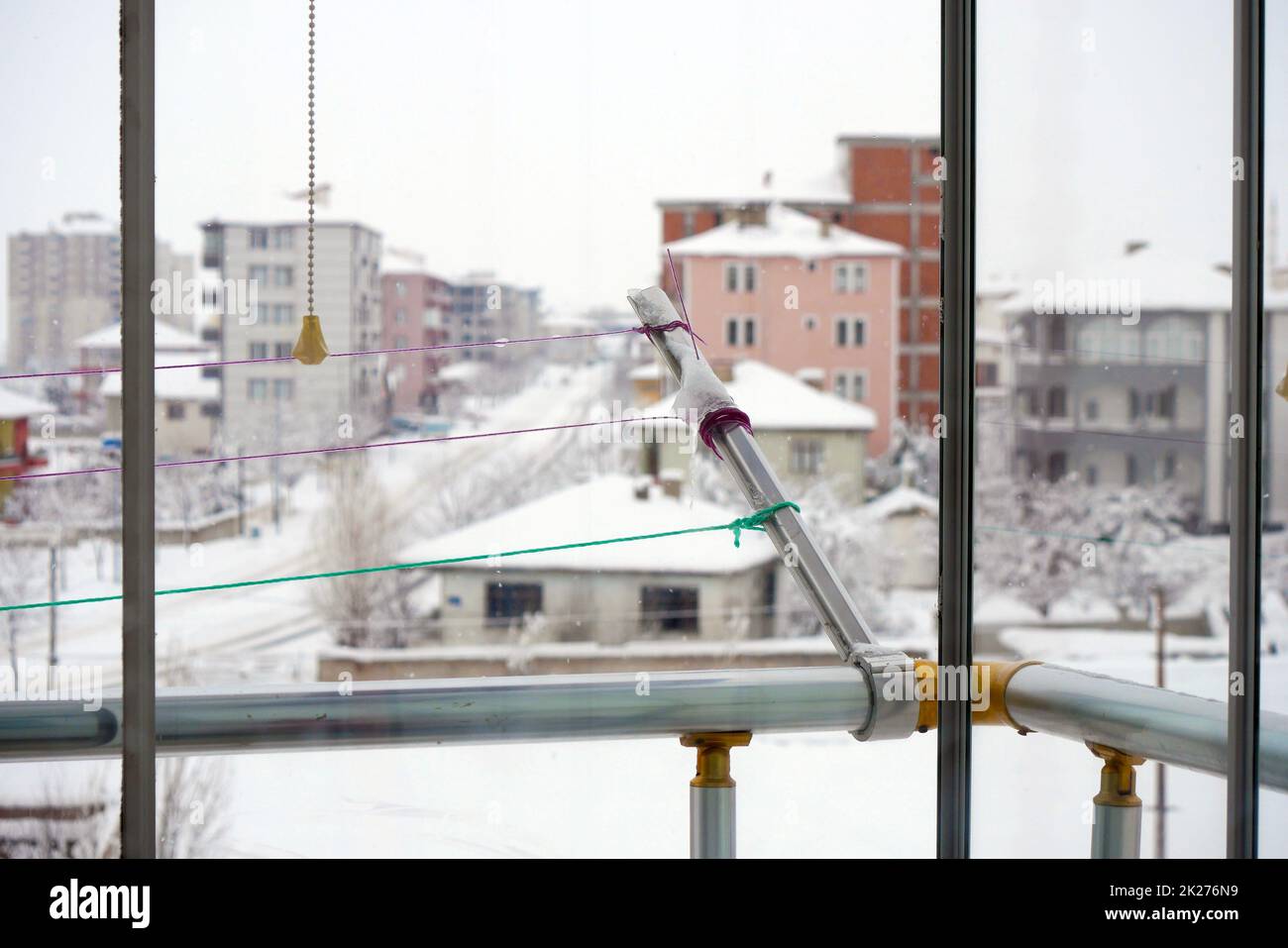 winter view from the glass balcony of a house,snow and the city,a city ...