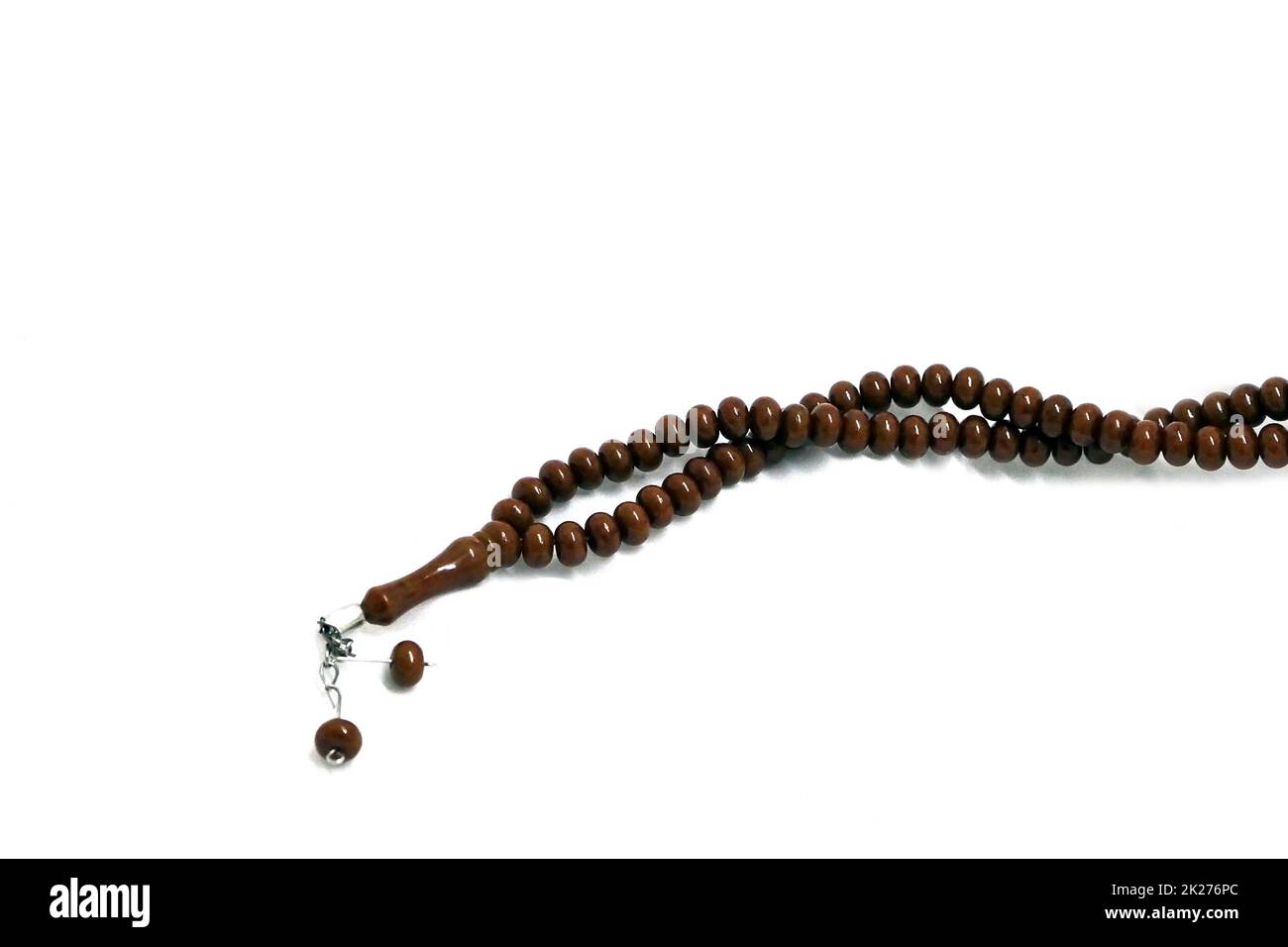 brown prayer rosary in white endless white, close-up rosary, islam and ...