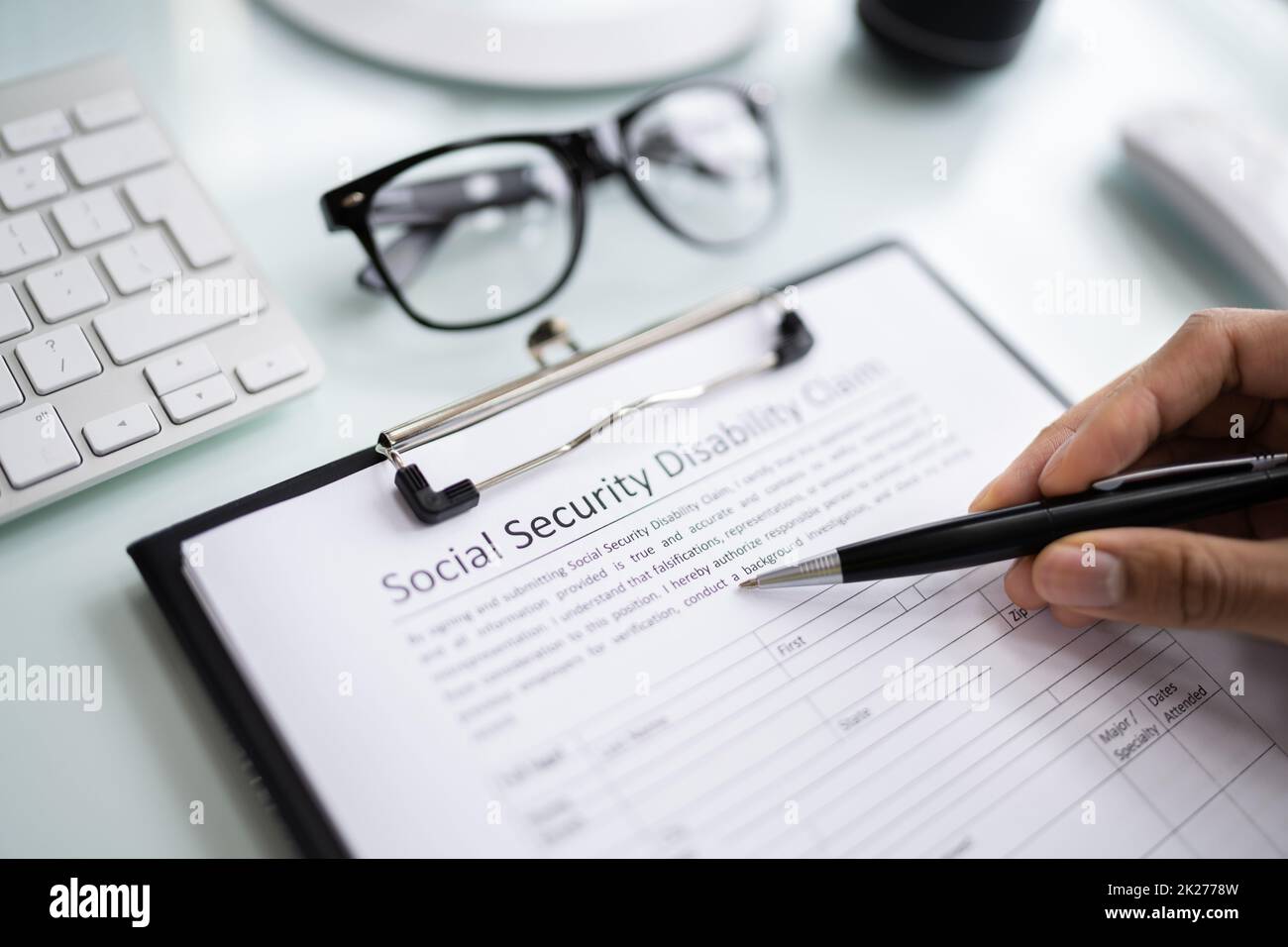 Person's Hand Filling Social Security Benefits Application Stock Photo ...