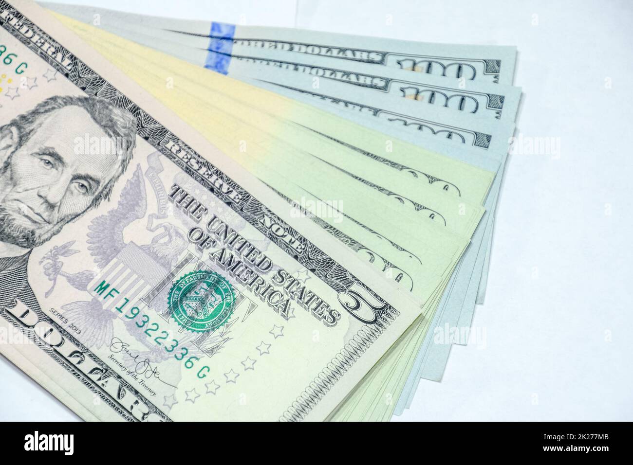 cistern of banknotes lies on a white table. Lots of dollars, a wad of ...