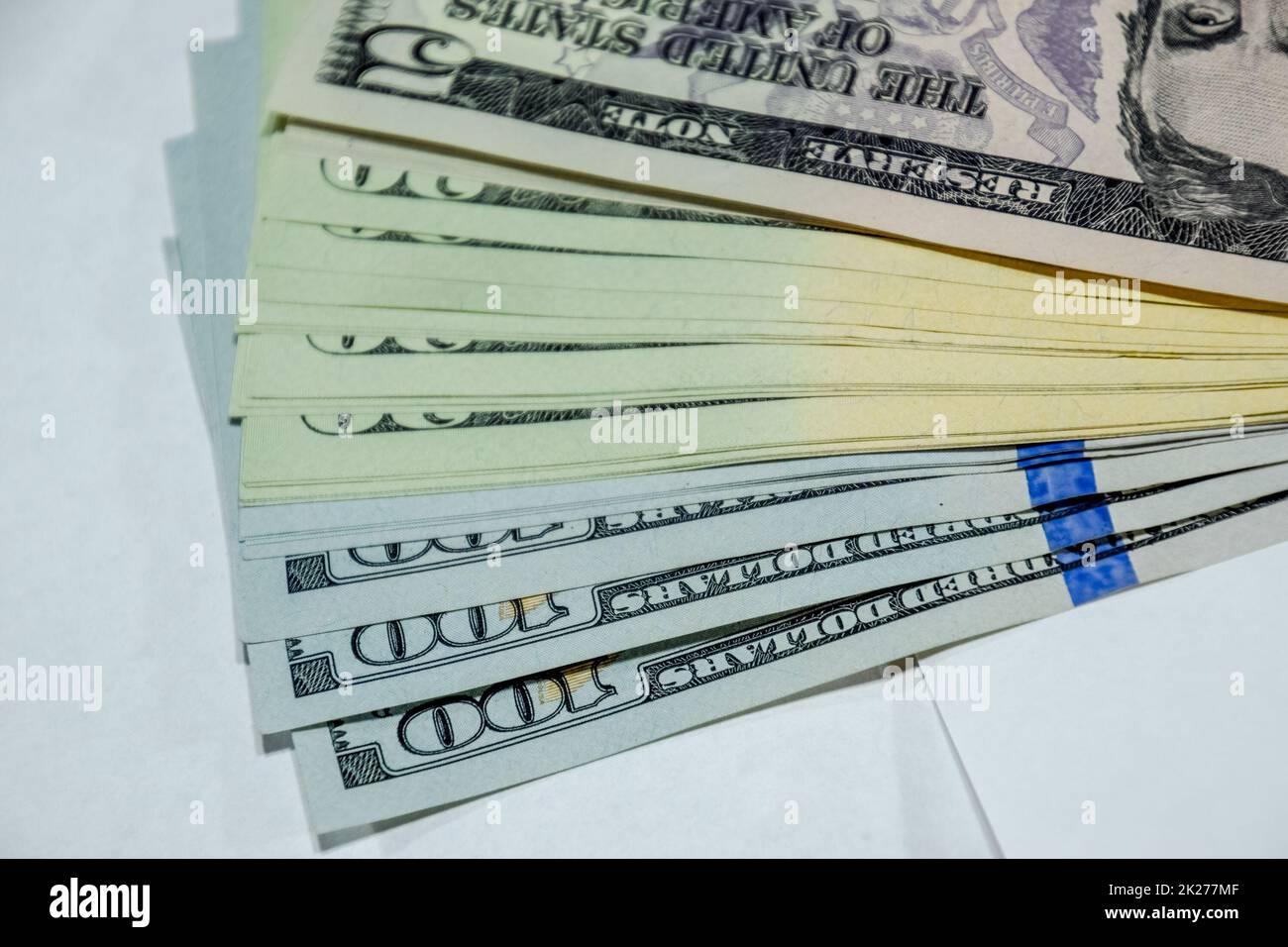 cistern of banknotes lies on a white table. Lots of dollars, a wad of ...