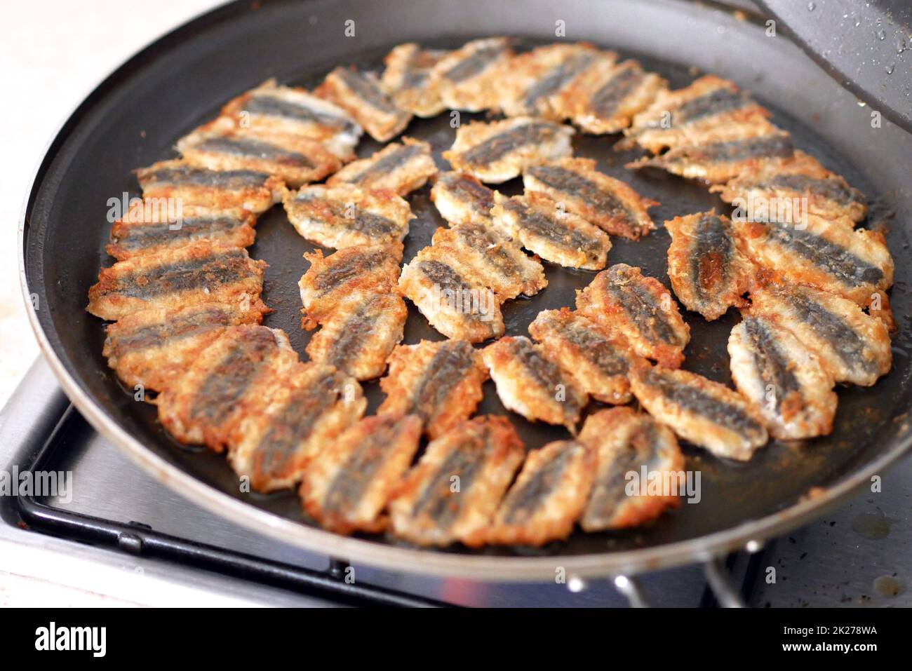 Anchovy is fried in a pan, cooking Turkish style anchovy, fried fish ...