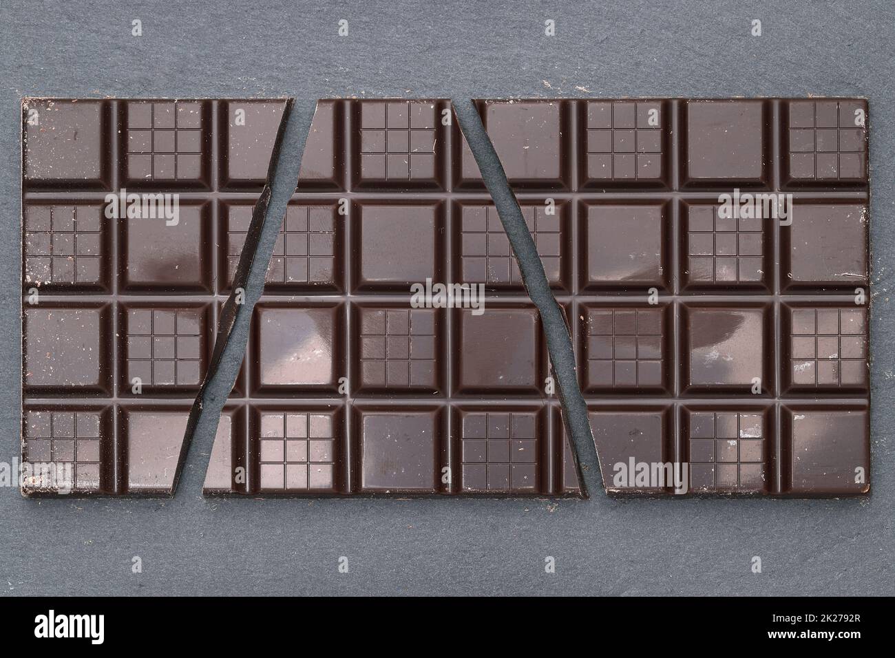 Cracked Dark Chocolate bar on a gray background Stock Photo - Alamy