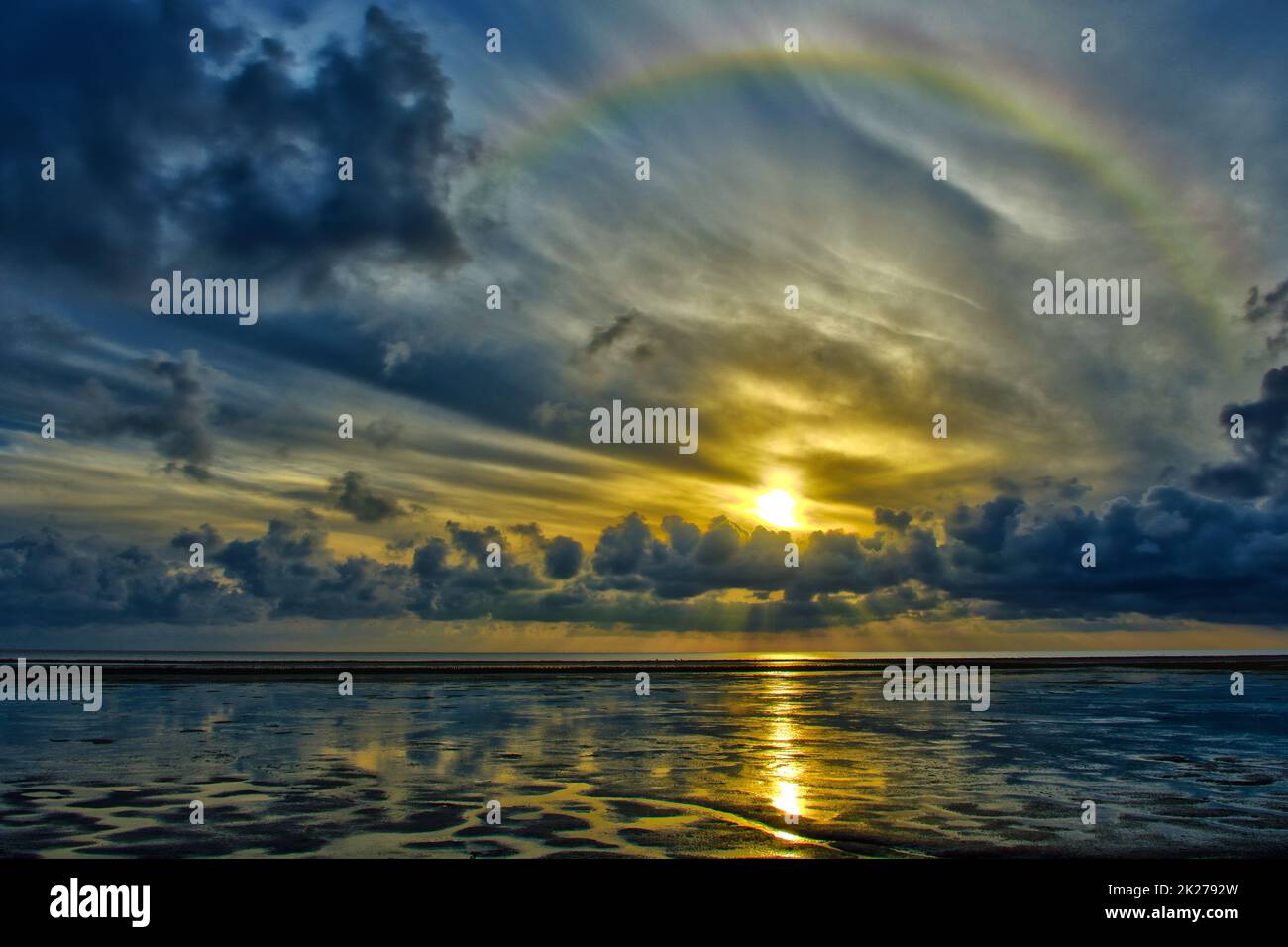 Rainbow over mud flat at low tide feahther clouds cumulus sunrise Stock ...