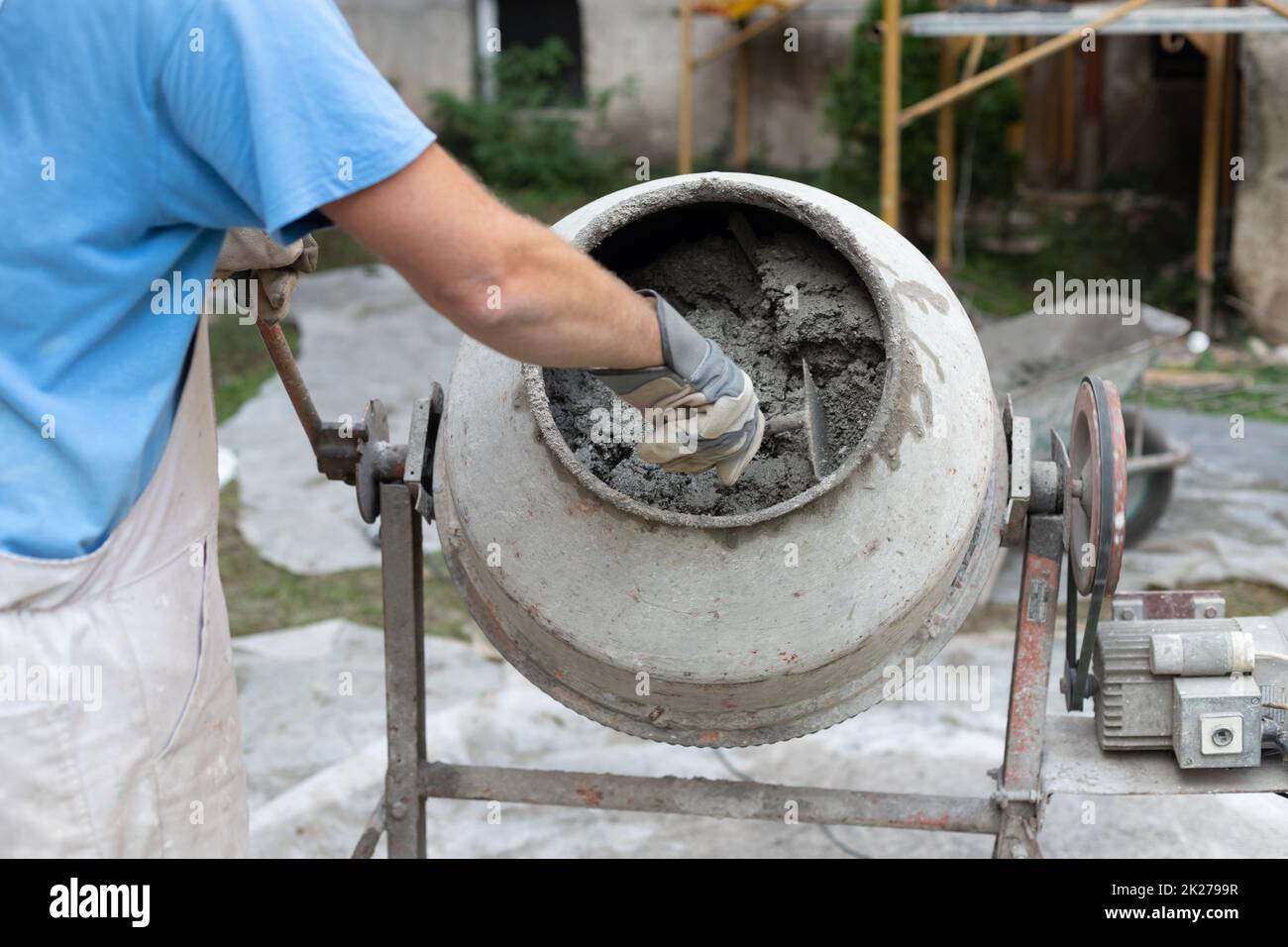 Labore worker operating concrete cement mixer at construction site ...