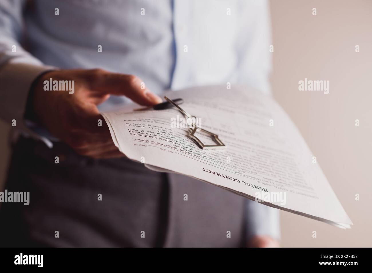 Manager offers keys to house holding contract in other hand Stock Photo ...