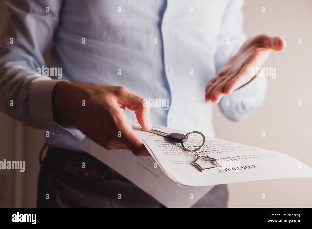 Manager offers keys to house holding contract in other hand Stock Photo ...