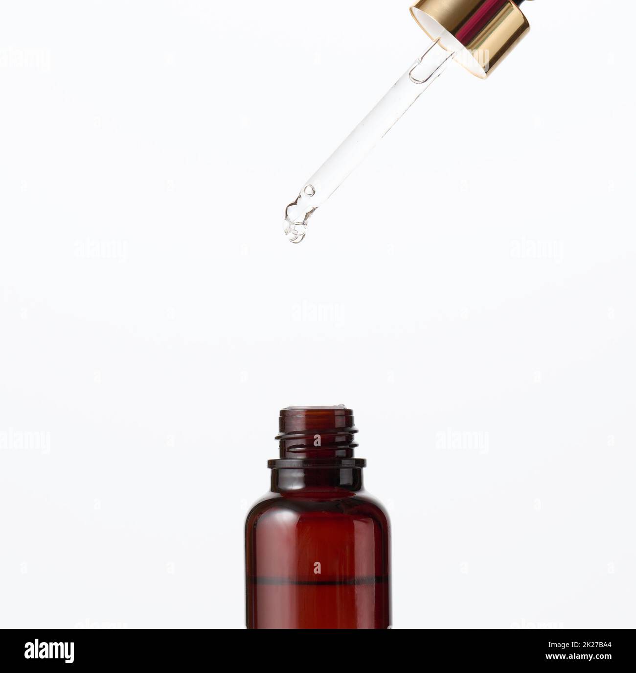 essential oil falling from the amber glass dropper. Blue bottle of ...