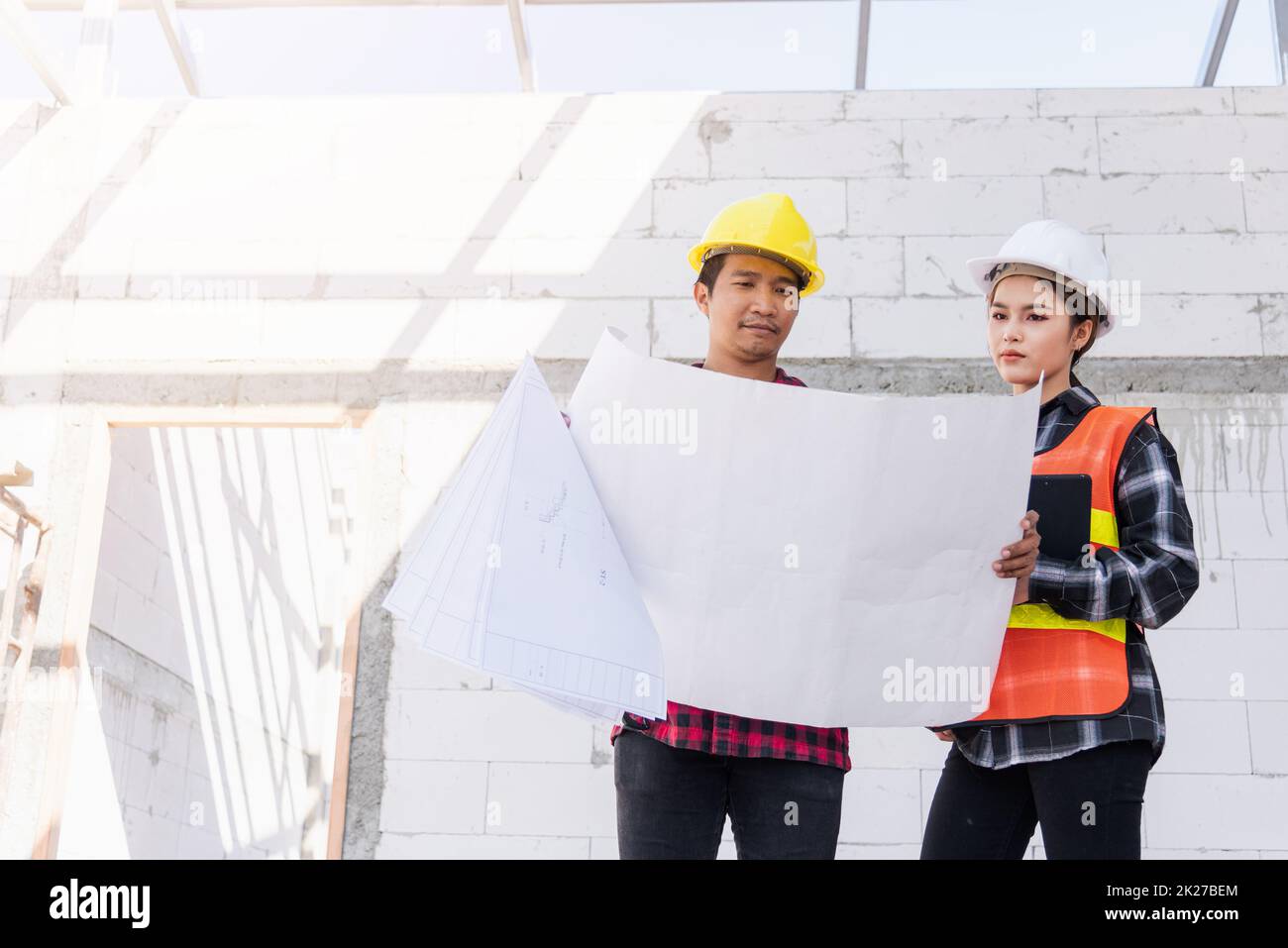 Architect and client discussing the plan with blueprint of the building ...
