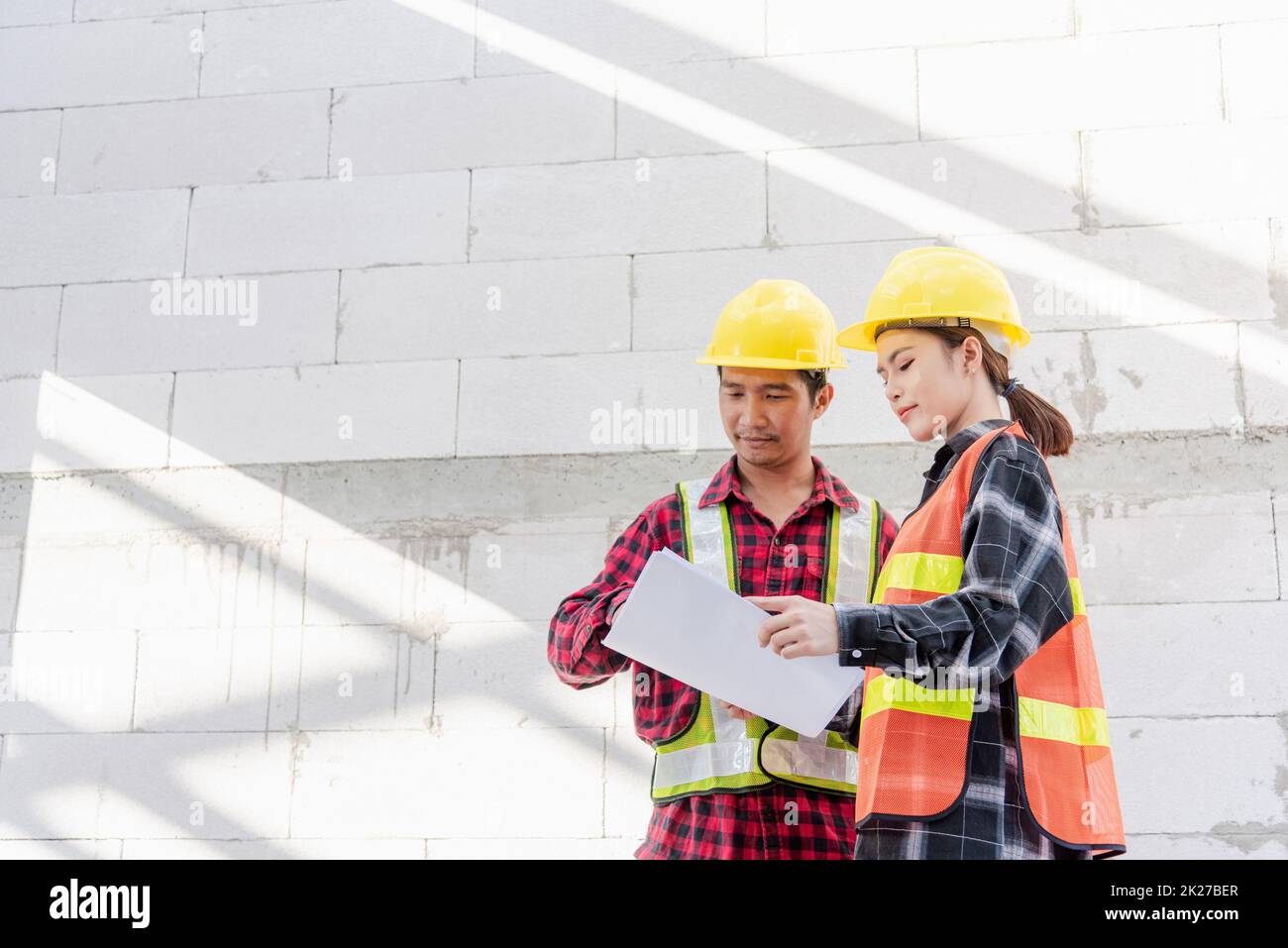 Architect and client discussing the plan with blueprint of the building ...