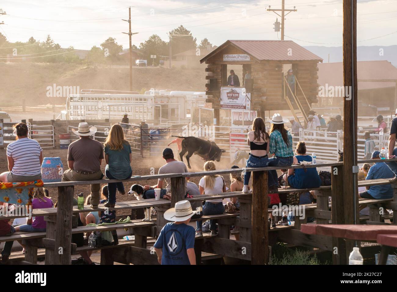 Spectators sitting on wooden benches watch the bull riding event at the ...