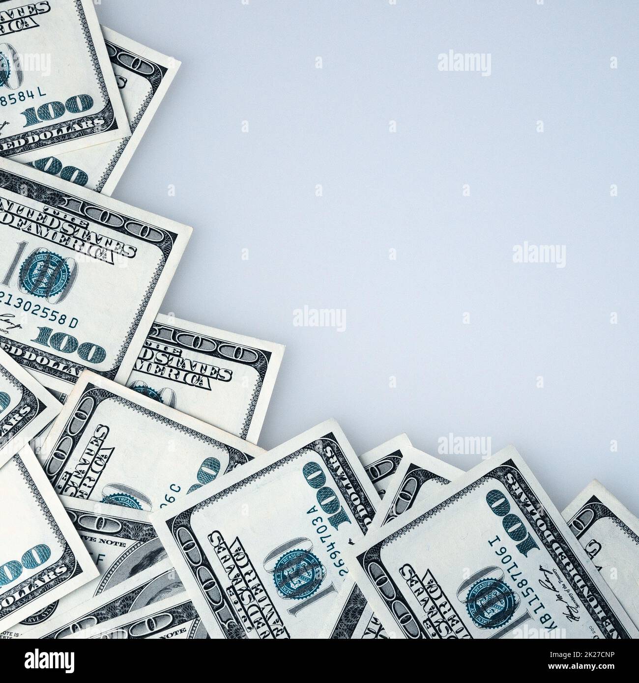Hundred-dollar bills are scattered in a frame on a white background ...