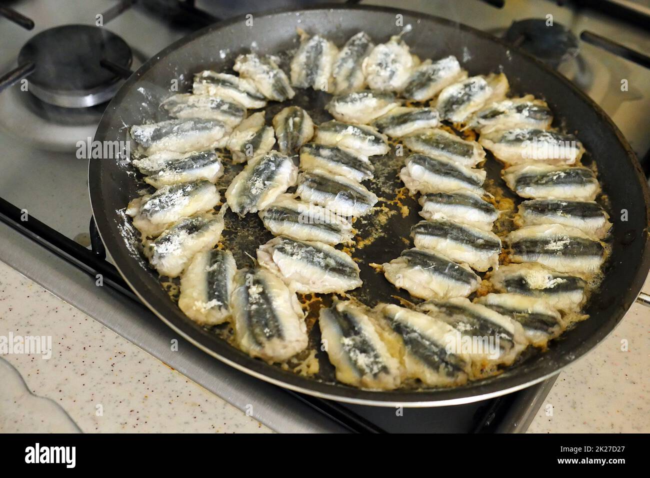 close-up sorted and cleaned raw anchovy,frying anchovy fish in a pan ...