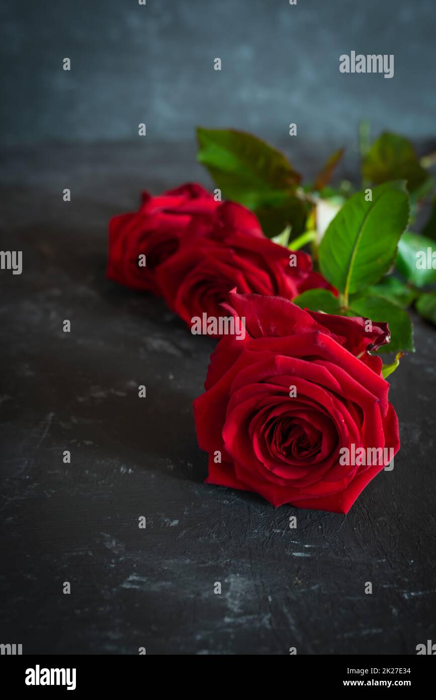 Red roses on black stone slab Stock Photo - Alamy