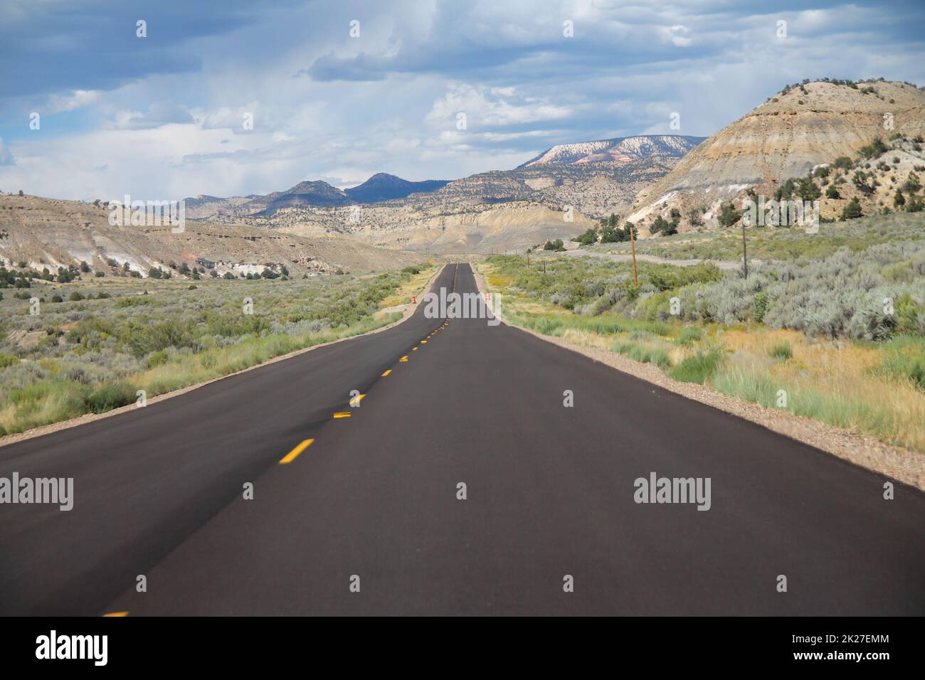 A straight and long road crossing a bushes field towards Kodachrome ...