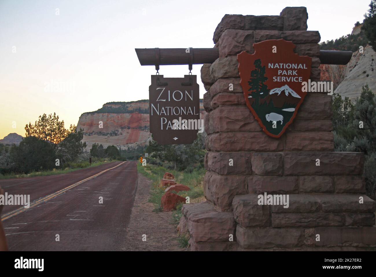 The traditional red rocks and wood sign at the entrance of Zion ...