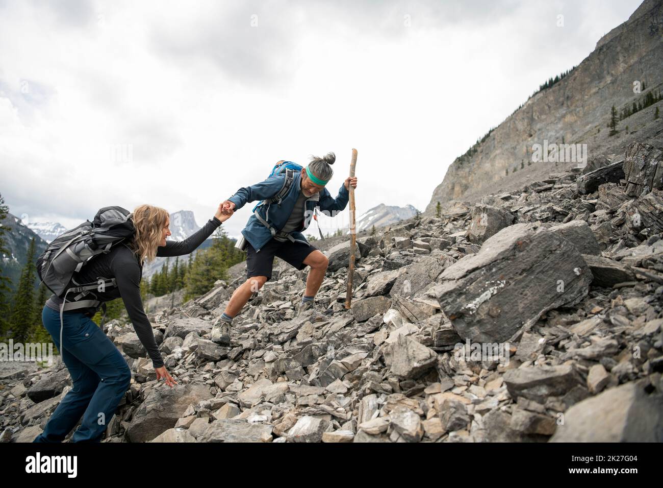 Couple holding hands climbing mountain hi-res stock photography and ...