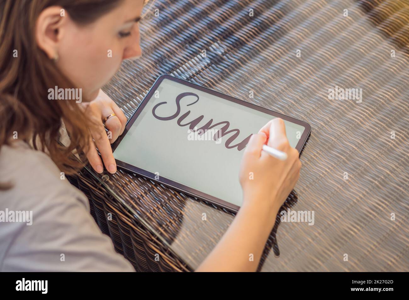 Calligrapher Young Woman writes phrase on digital tablet. Inscribing ...