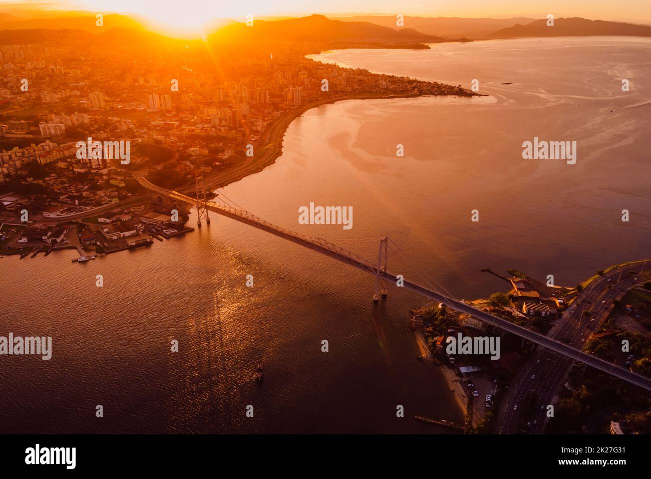 Aerial view of city and Hercilio luz bridge with bright sunset in ...