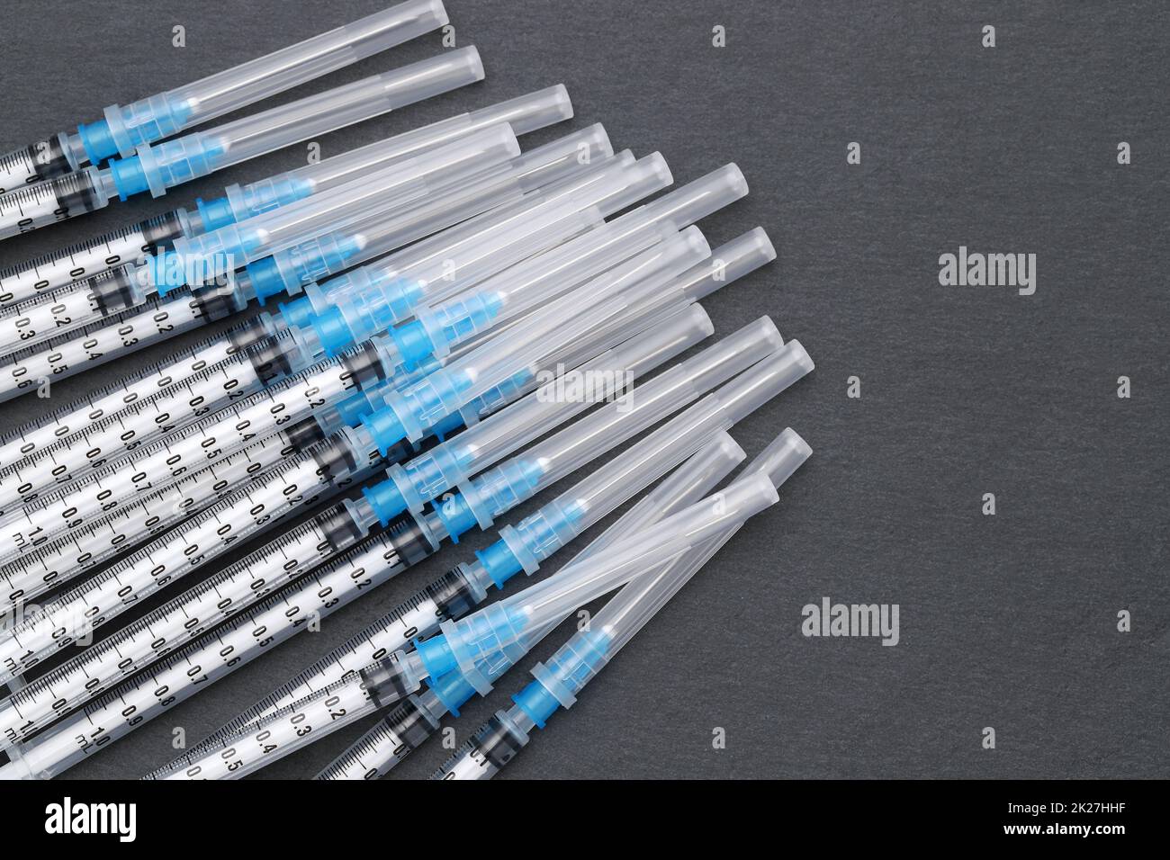 Stack of injection syringe on dark grey background Stock Photo - Alamy