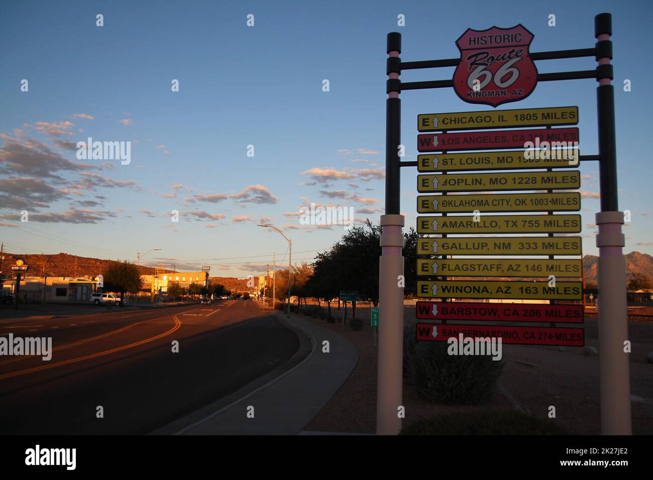 The traffic sign with all the destinations in a orange sunset at ...
