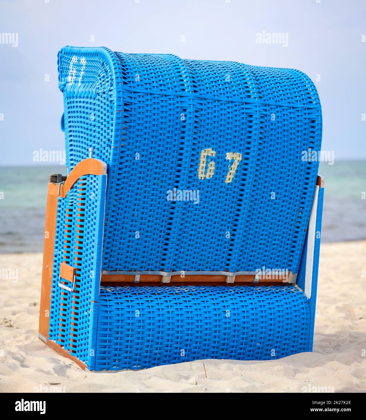 A blue beach chair stands on the Baltic Sea beach and is waiting for ...