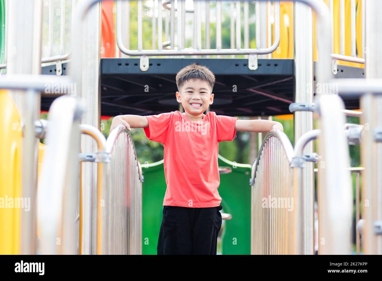 child playing on outdoor playground, happy preschool little kid having funny while playing on ...