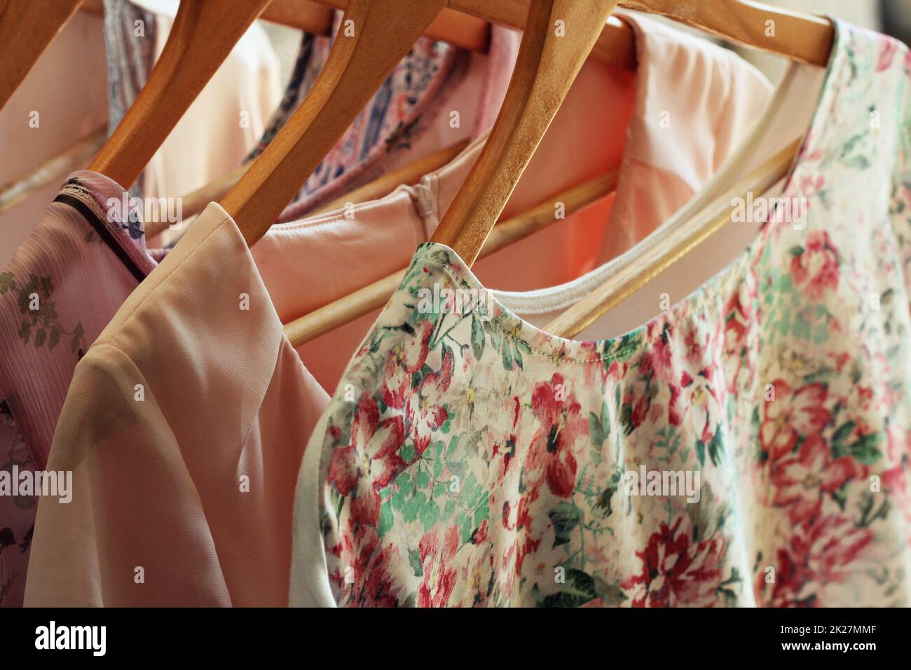 collection of women's clothes hanging on rack Stock Photo - Alamy