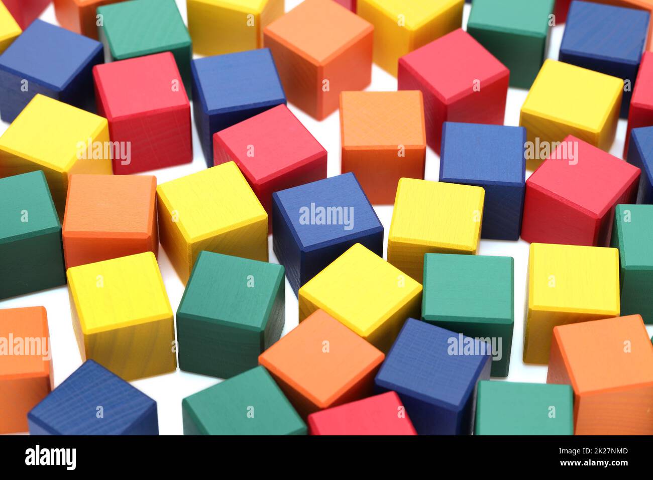 small wooden colorful building blocks scattered on a white background ...