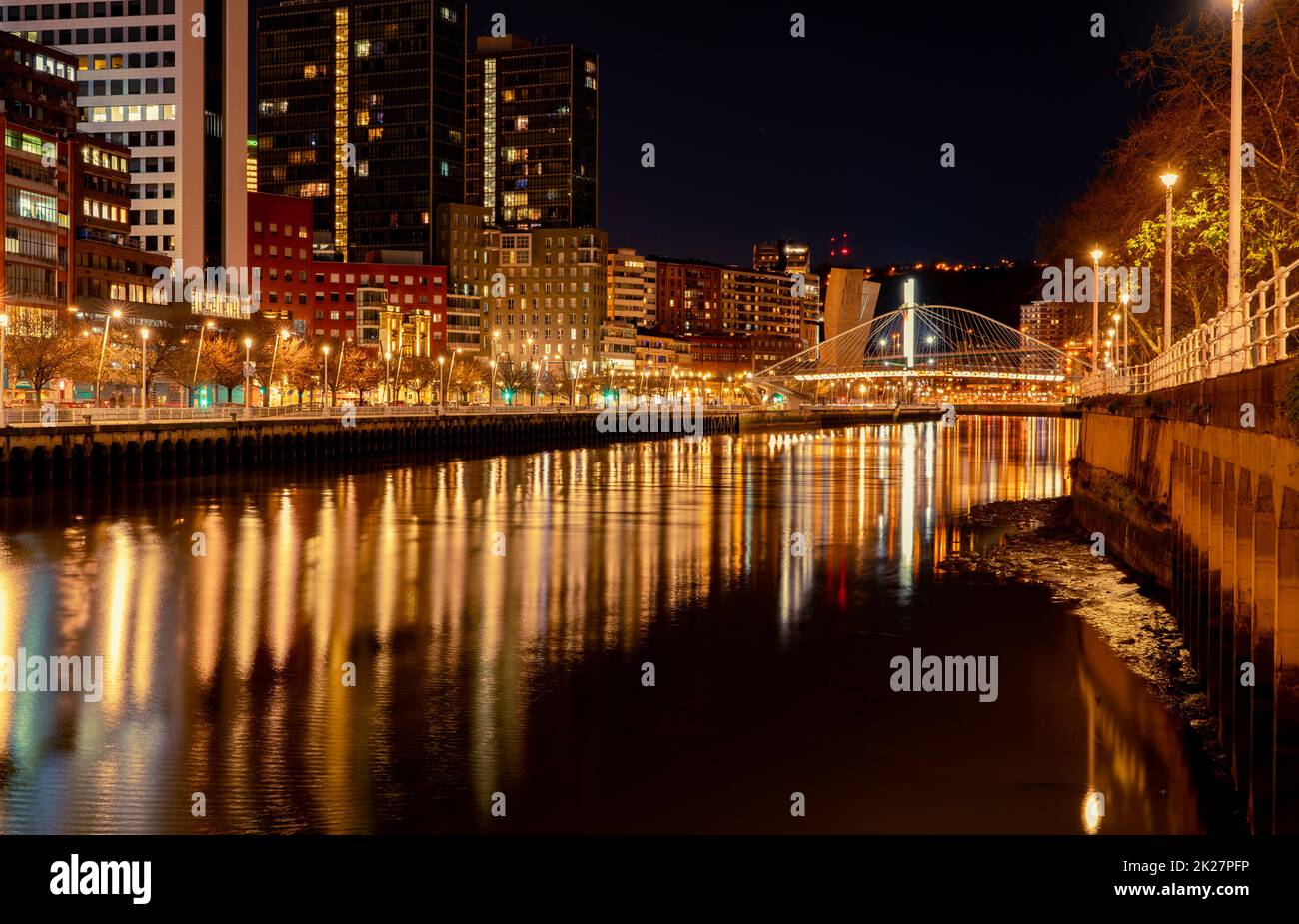 Cityscape of modern building in the night near the river and bridge ...