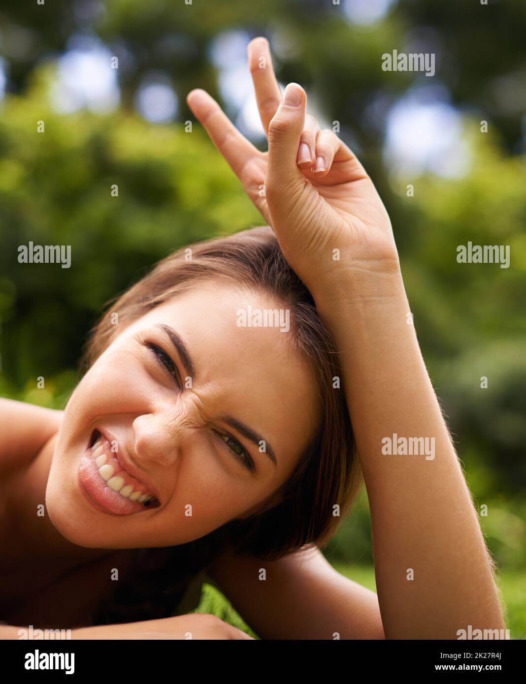 She Just Loves Being Outdoors Portrait Of An Attractive Young Woman Lying On The Grass Stock
