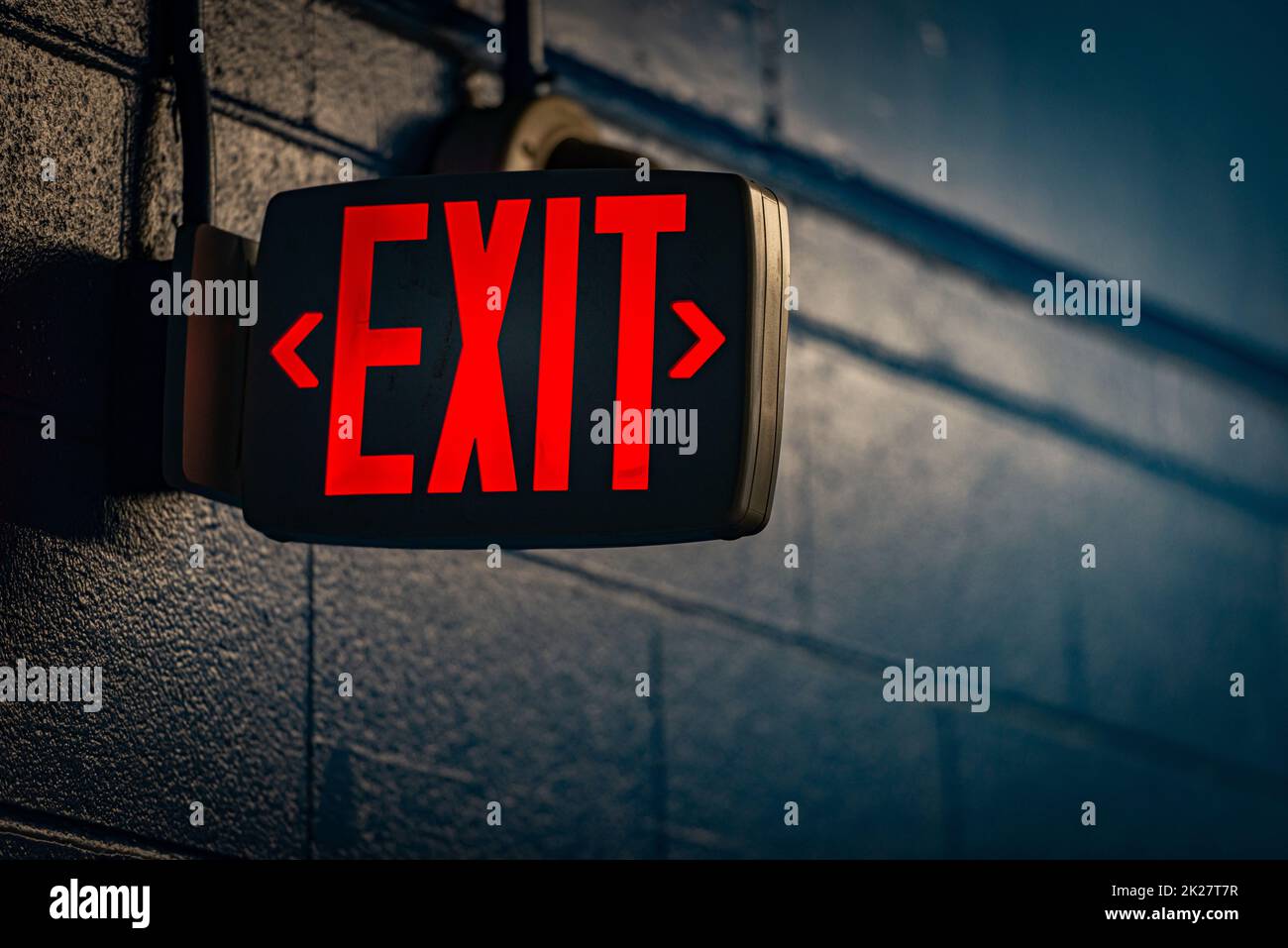 glowing exit sign by night on wall Stock Photo - Alamy