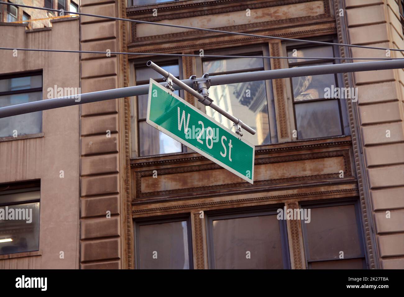 Green big West 28th Street sign hanging on a arch pole in the streets ...